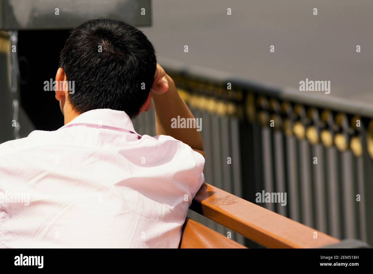 Rear view of a man reclining against a railing, Madrid, Spain Stock ...