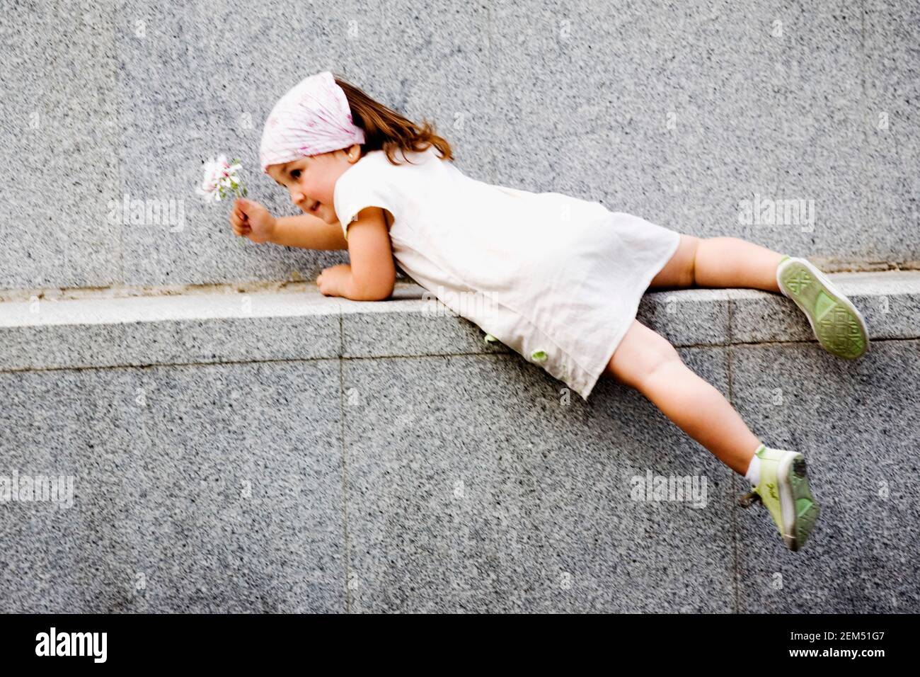 Girl holding a flower and climbing steps Stock Photo - Alamy