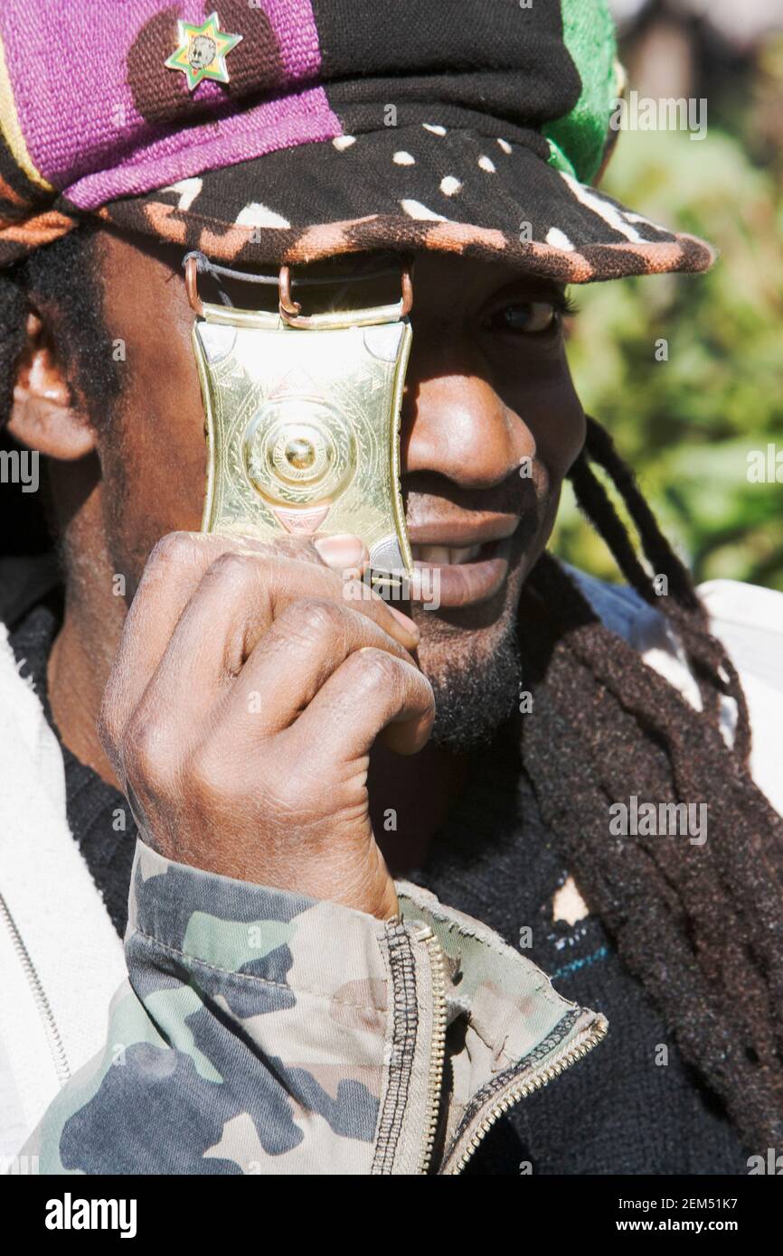 Portrait of a young man covering his eye with a buckle Stock Photo - Alamy