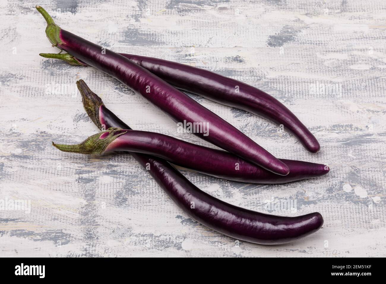 Purple chinese eggplants on a wooden surface Stock Photo - Alamy