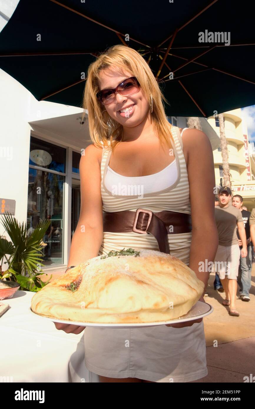 Portrait of a waitress holding a plate of naan bread Stock Photo - Alamy