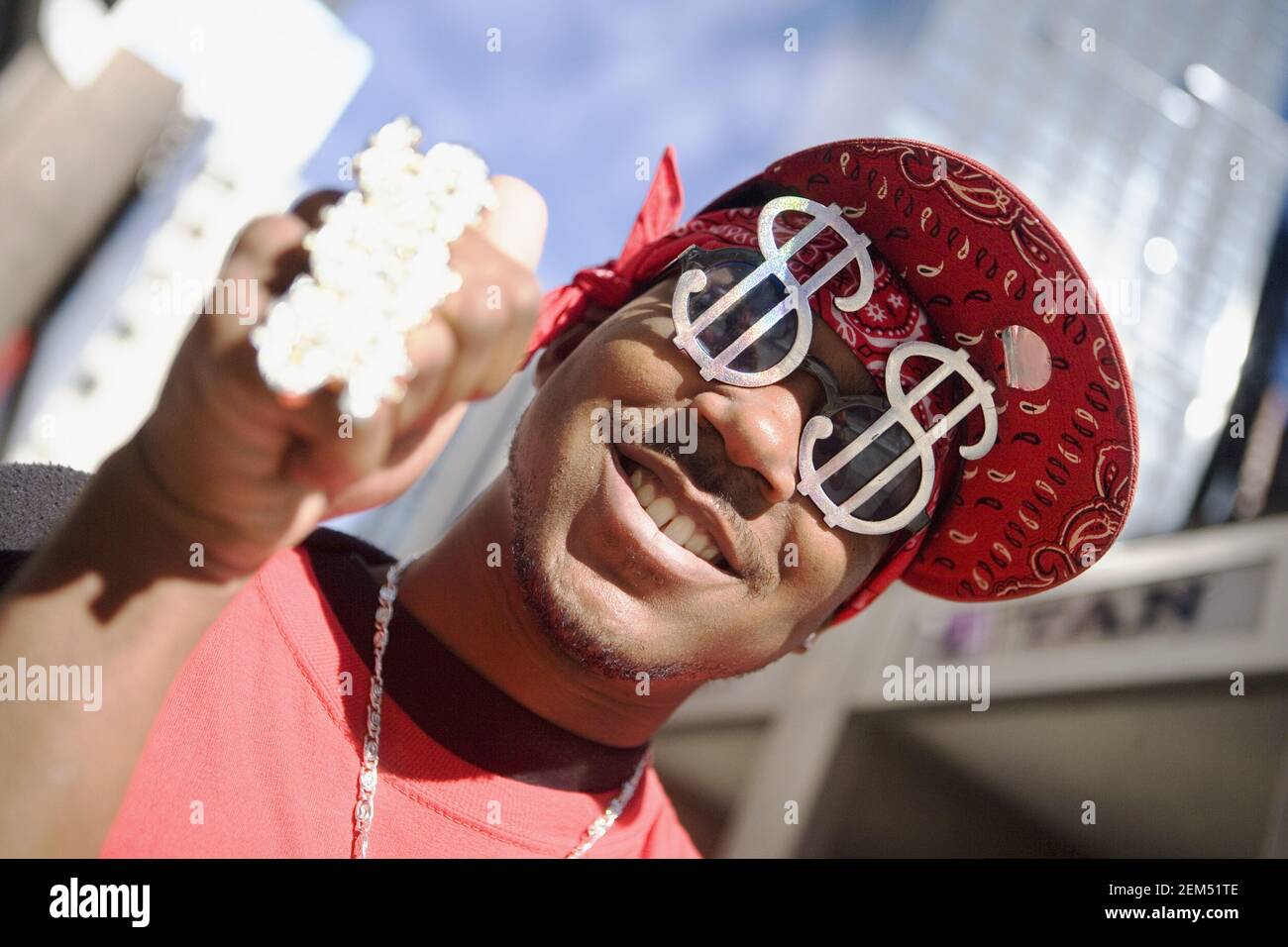 Close-up of a young man wearing dollar sign sunglasses and smiling, New ...