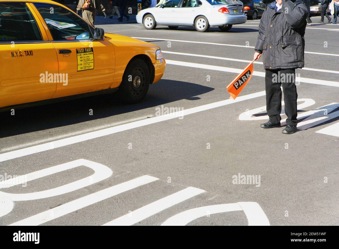 Low section view of a man standing in a parking lot with a parking sign ...