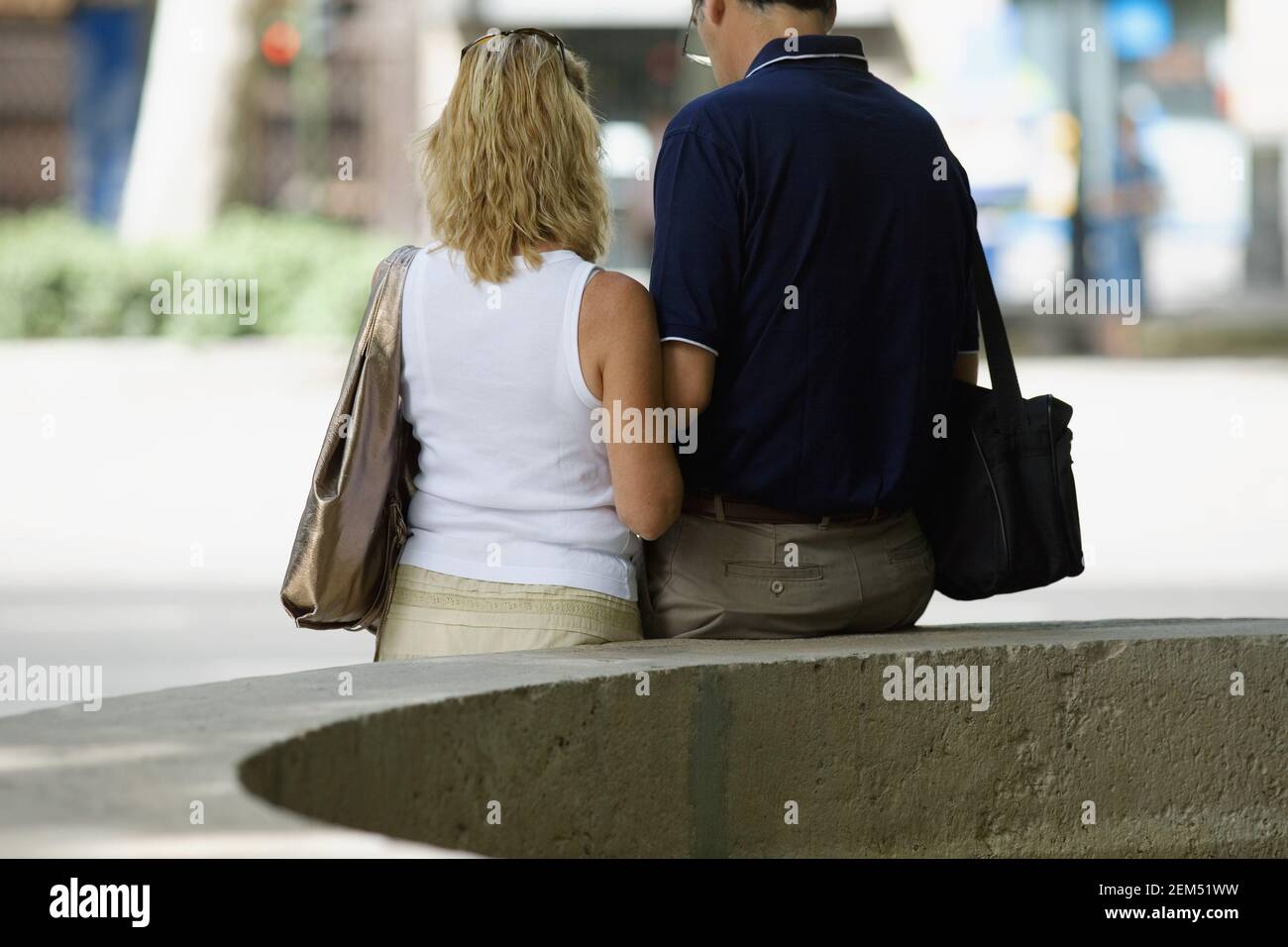 Rear view of a couple standing together near a well Stock Photo - Alamy