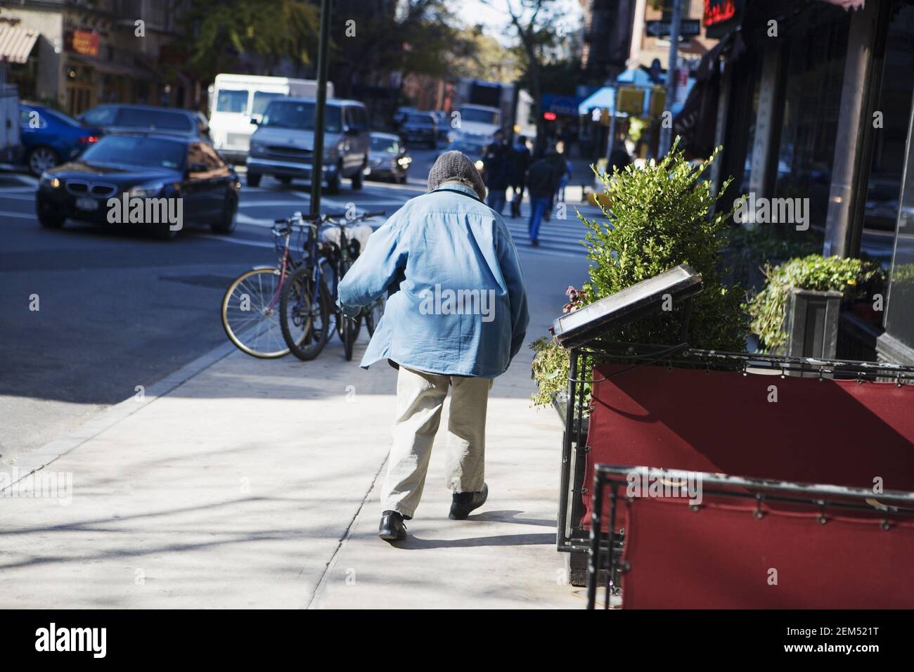 Rear view of a man walking on a walkway Stock Photo - Alamy