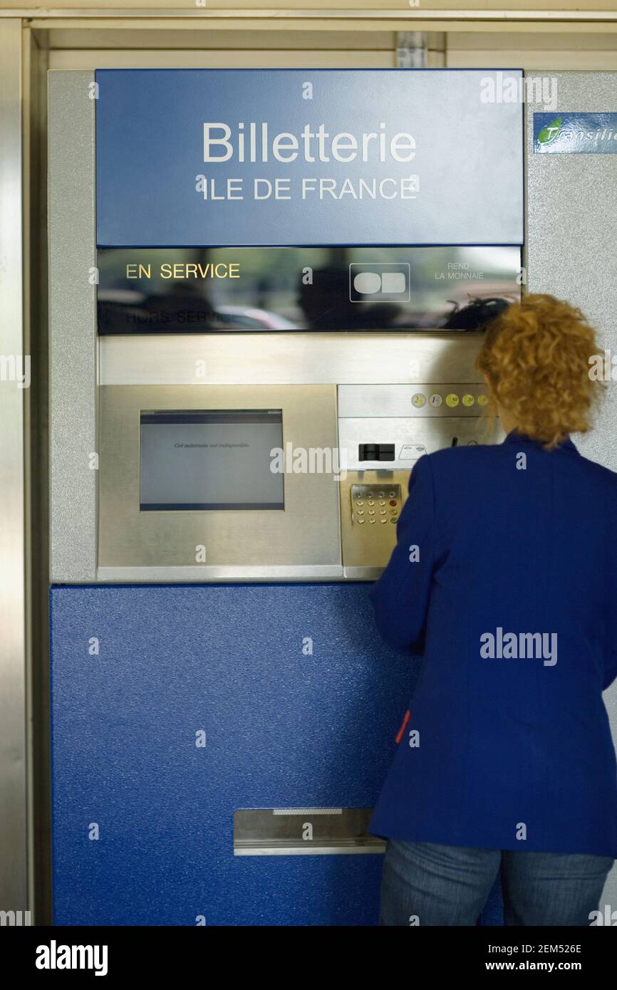 Rear view of a woman standing in front of an ATM Stock Photo - Alamy