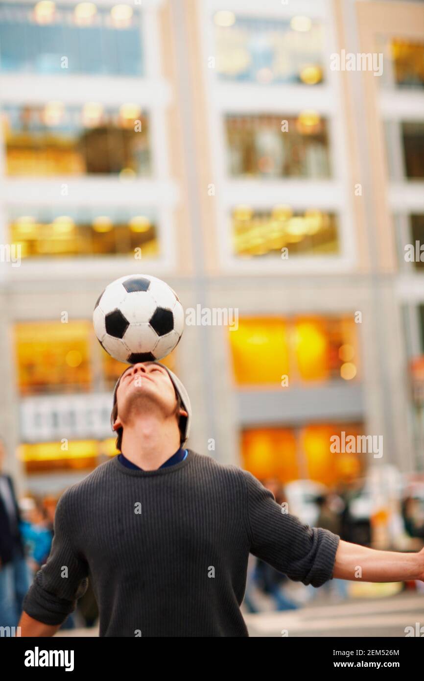 Young man heading a soccer ball Stock Photo - Alamy