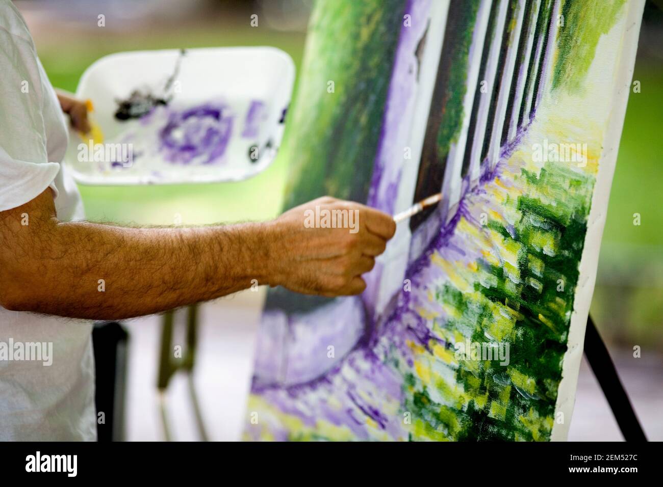 Close-up of a human hand painting on an easel Stock Photo - Alamy