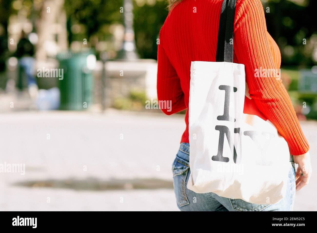 Rear view of a woman carrying a shopping bag on her shoulder Stock ...