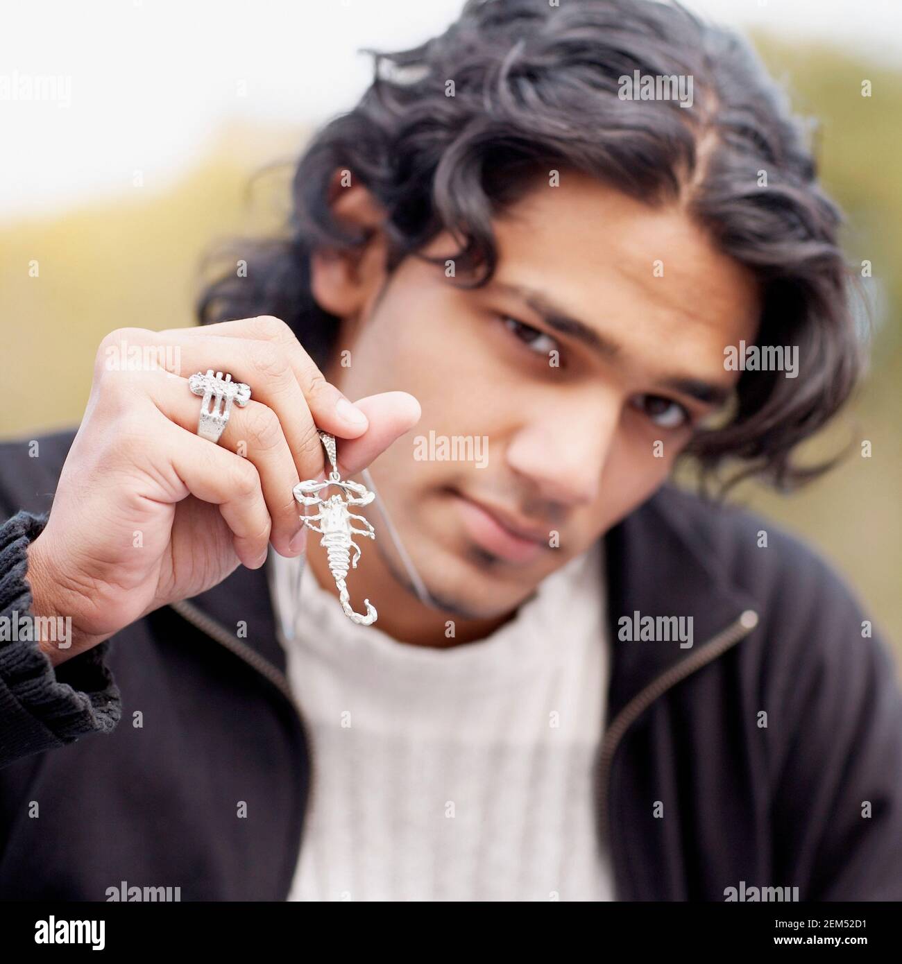 Portrait of a young man showing his locket Stock Photo - Alamy
