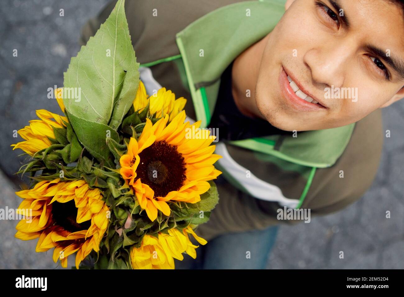 Portrait of a young man holding sunflowers Stock Photo - Alamy