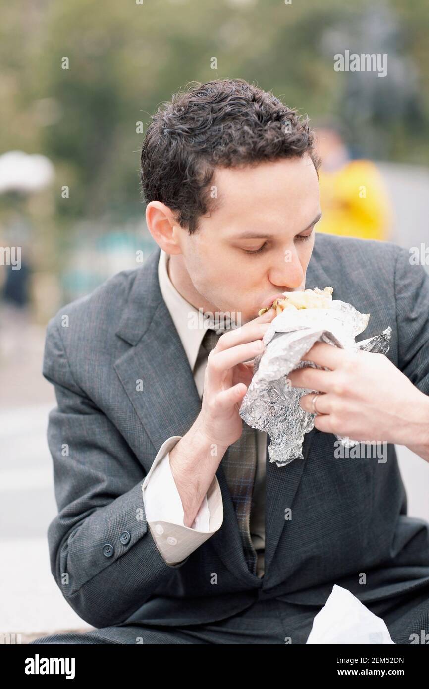 Close-up of a young man eating a sandwich Stock Photo - Alamy