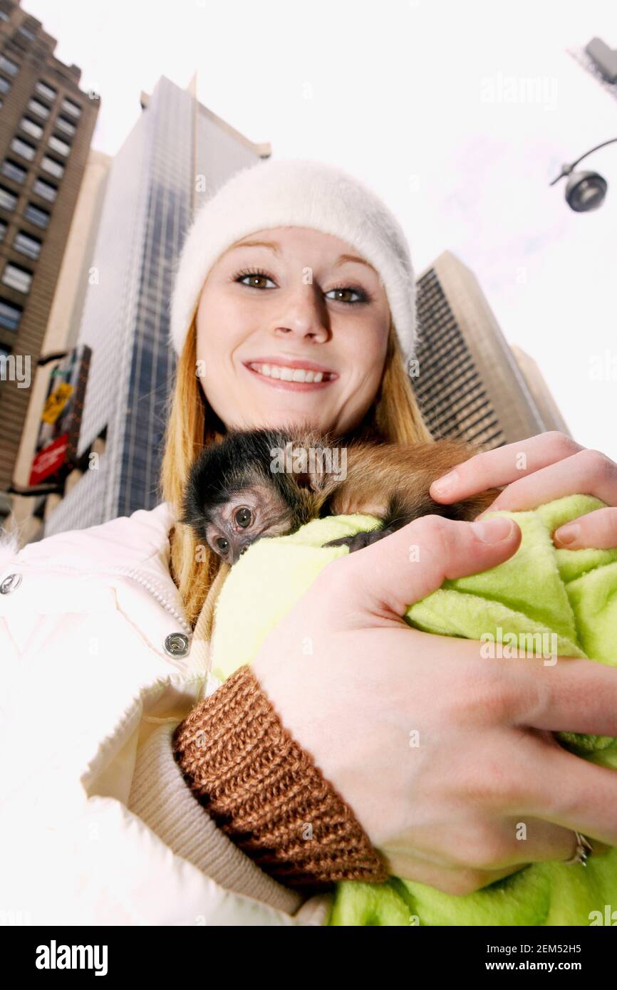 Portrait of a young woman hugging a baby monkey Stock Photo - Alamy