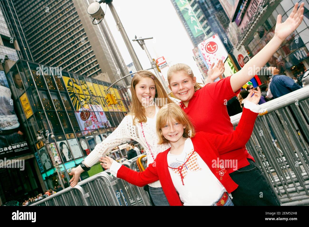 Portrait of three girls standing with their arms outstretched Stock ...