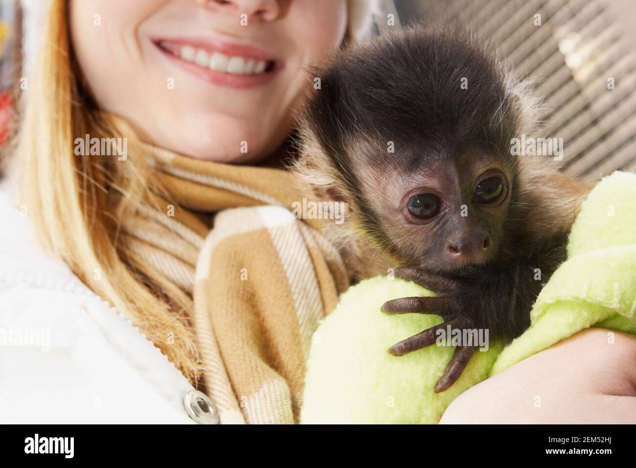 Close-up of a young woman hugging a baby monkey Stock Photo - Alamy