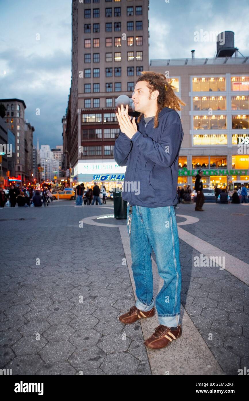 Side profile of a young man standing at a town square Stock Photo - Alamy