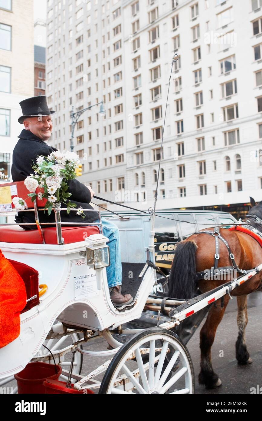 Portrait of a mature man sitting on a horse drawn carriage Stock Photo ...
