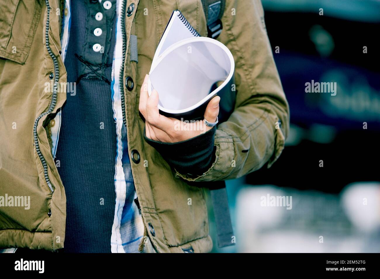 Mid section view of a man holding a spiral notebook Stock Photo - Alamy