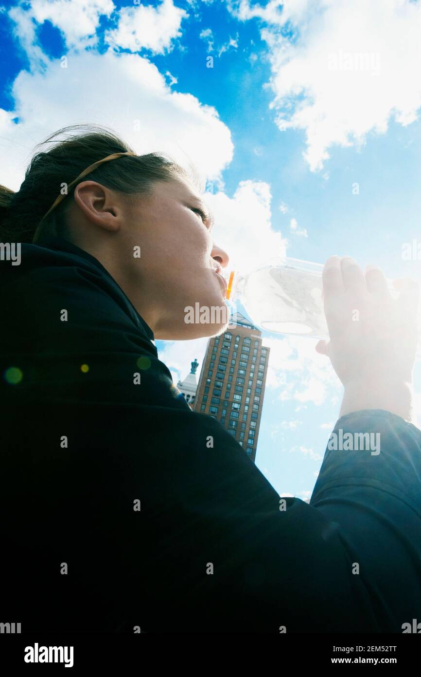 Low angle view of a young woman drinking water Stock Photo - Alamy