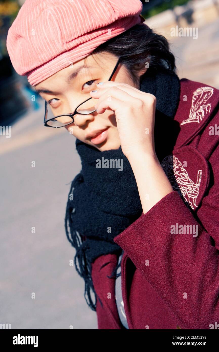 Portrait of a young woman peeking over her eyeglasses Stock Photo - Alamy