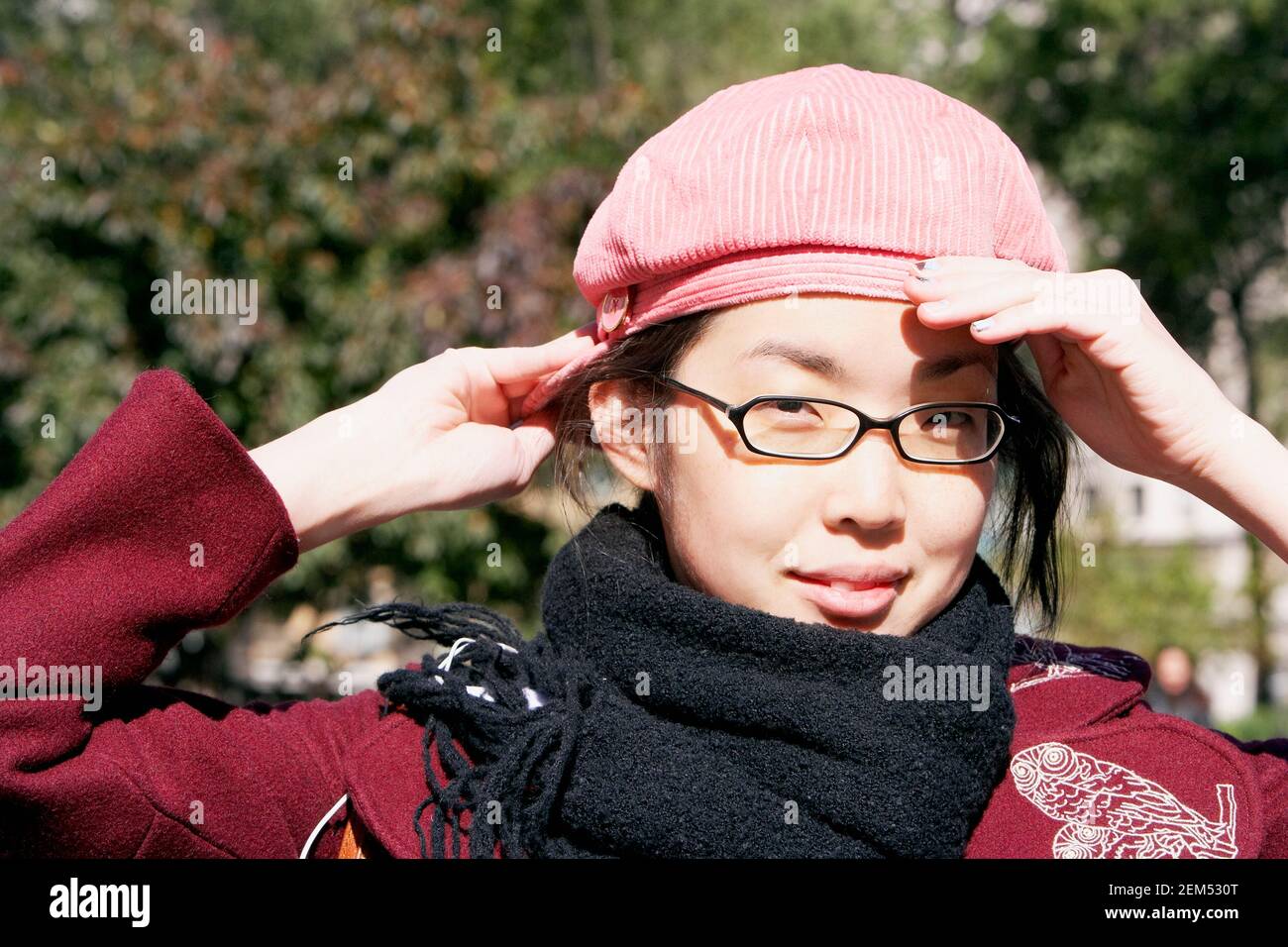 Portrait of a young woman adjusting her cap Stock Photo - Alamy