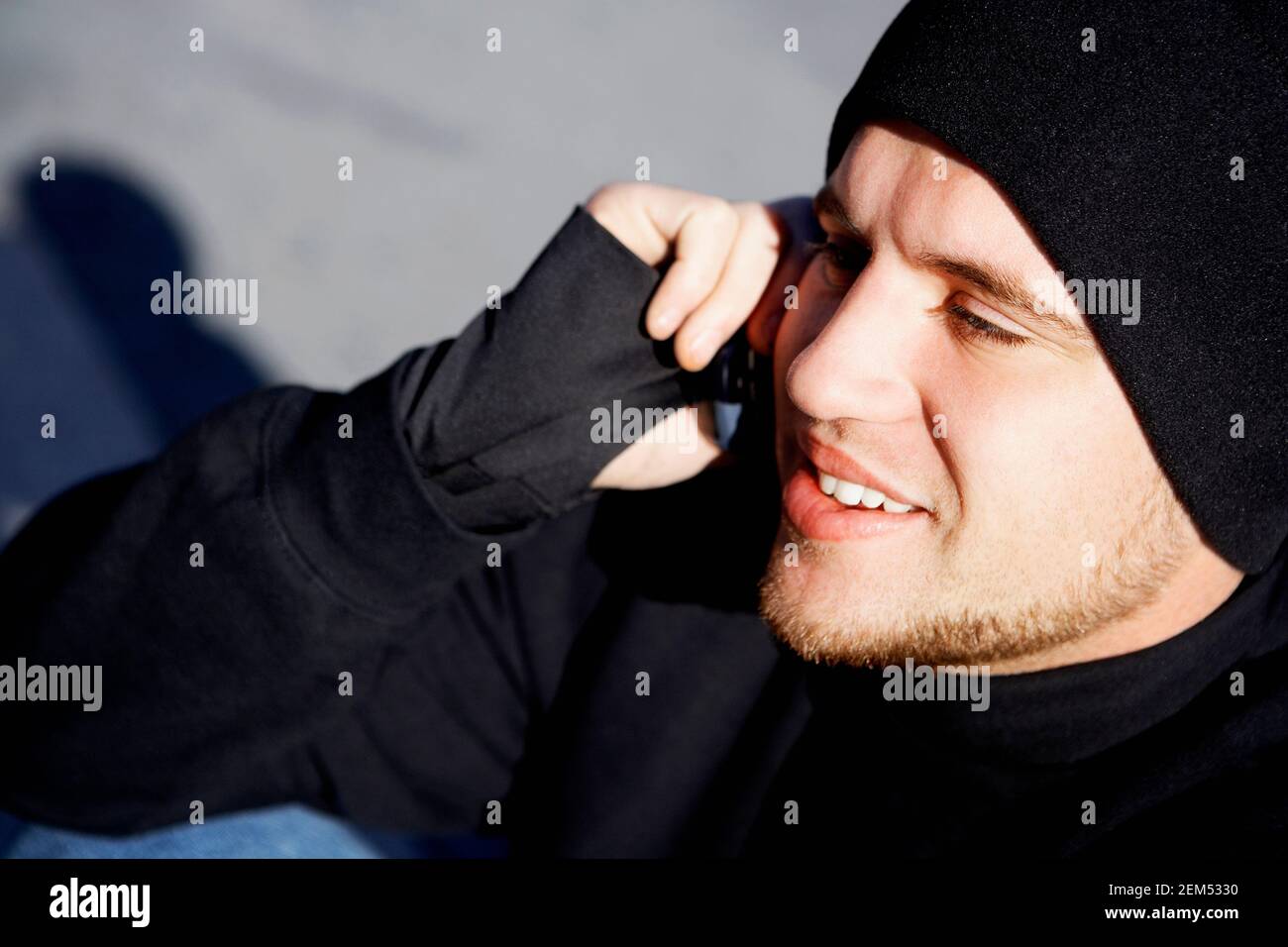 Side profile of a young man talking on a mobile phone Stock Photo - Alamy