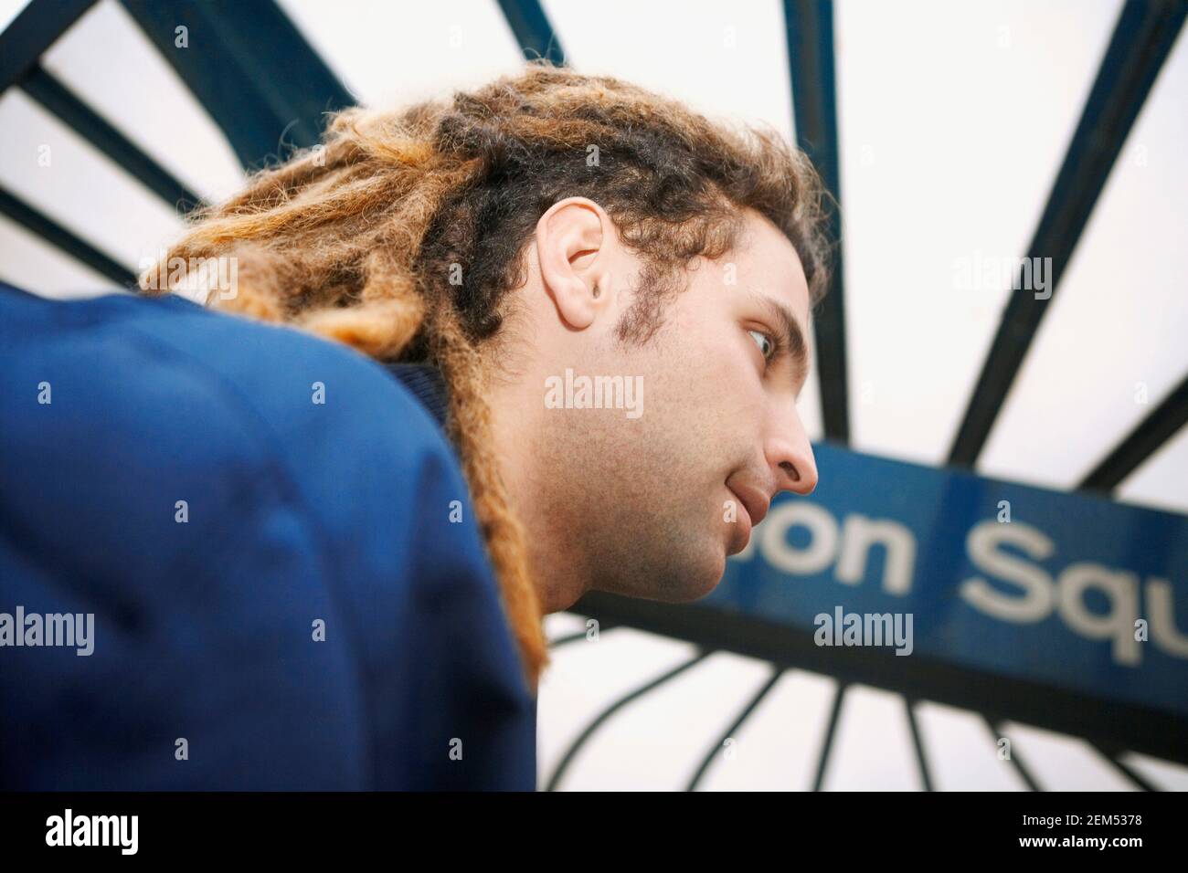 Side profile of a young man smiling in front of a signboard, Union ...