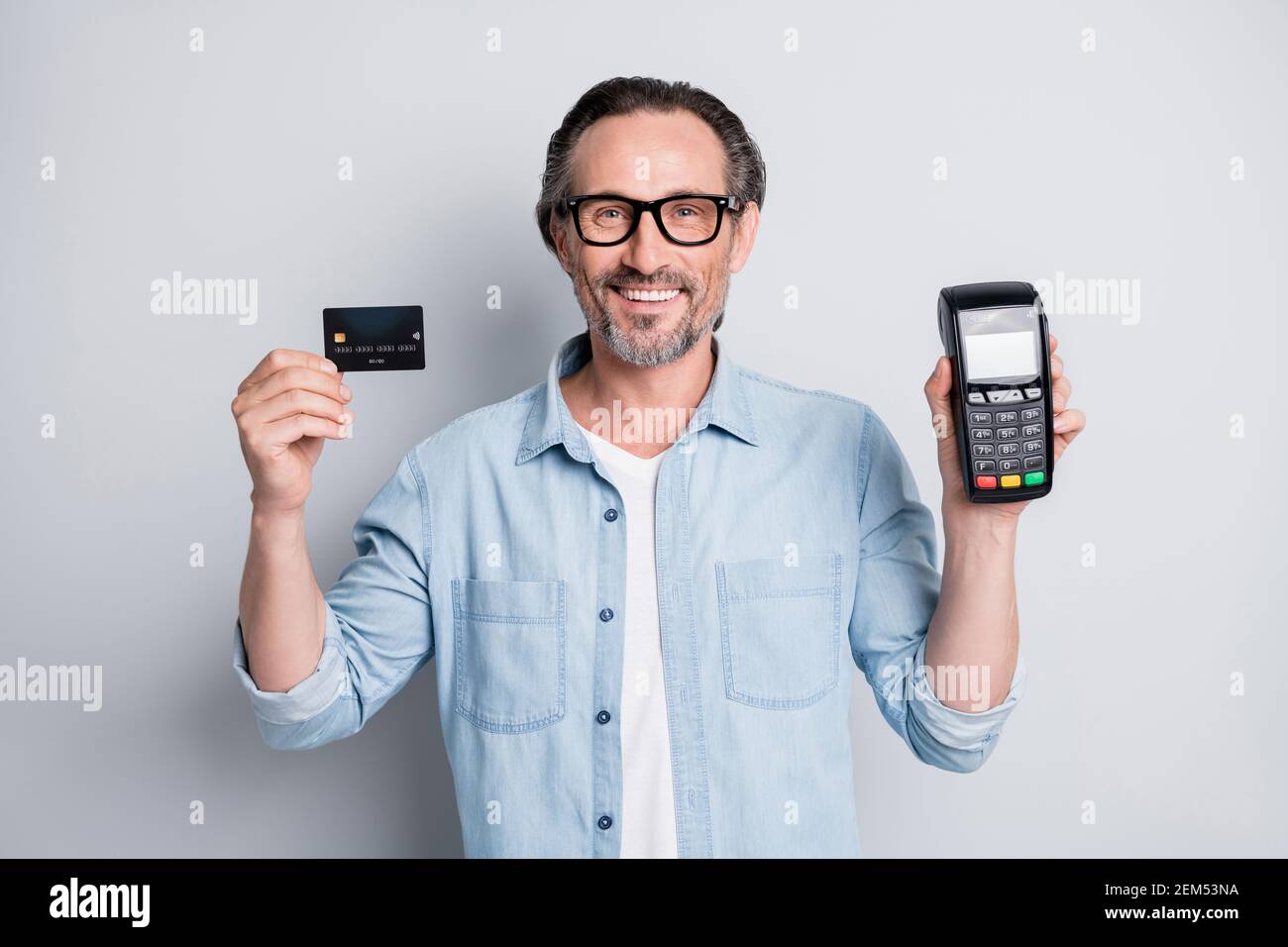 Portrait of handsome smart cheerful mature man holding in hands pos ...