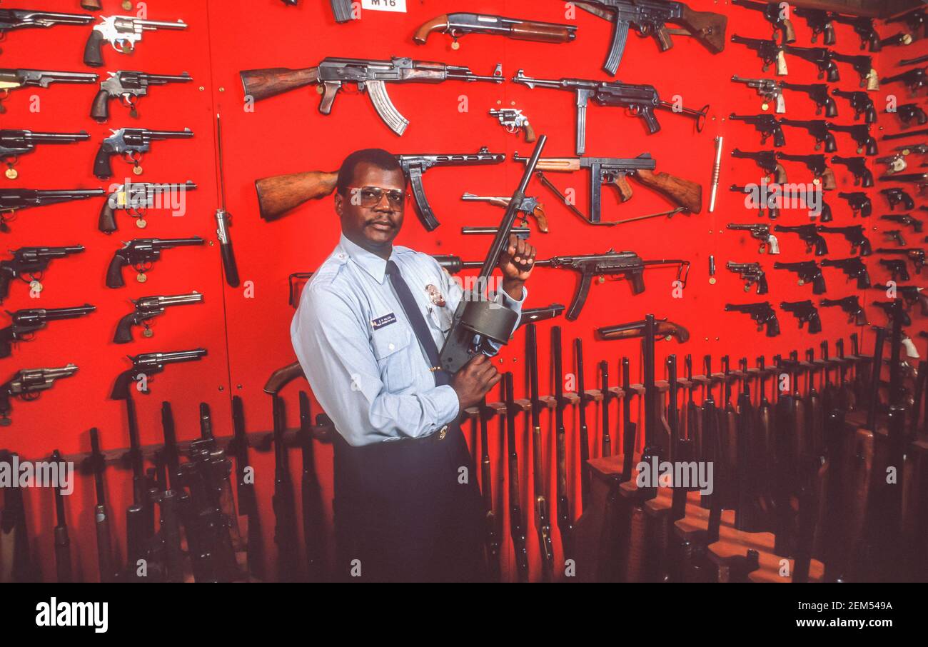WASHINGTON, DC, USA - Police officer holds gun in front of display of ...