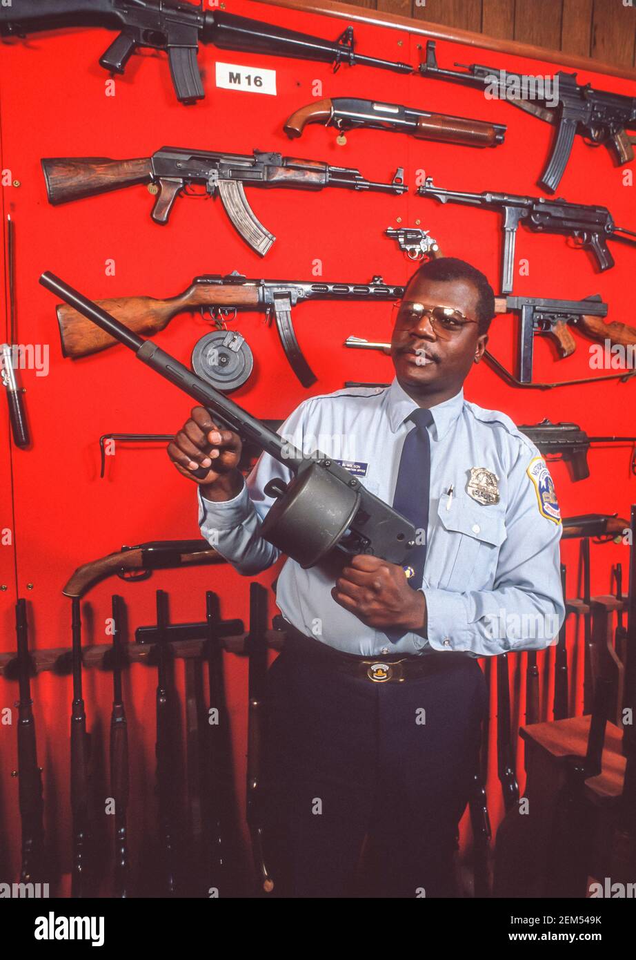 WASHINGTON, DC, USA - Police officer holds gun in front of display of ...