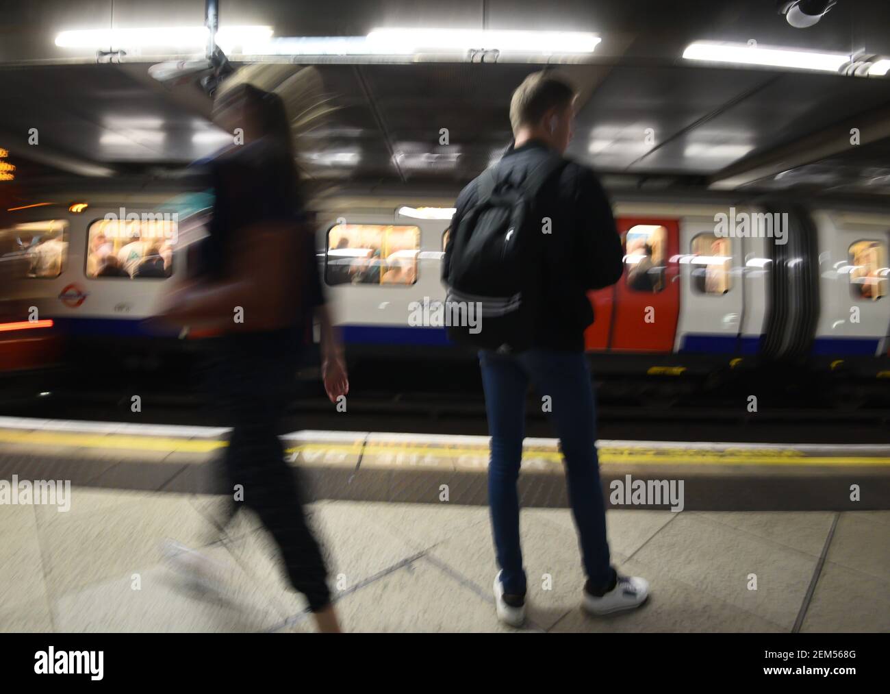 Random passenger people at the underground tube station with moving ...