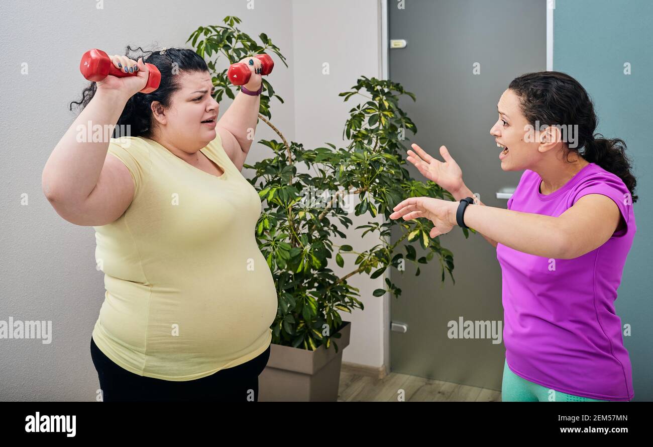 Personal trainer motivates fat woman during sports and fitness with ...