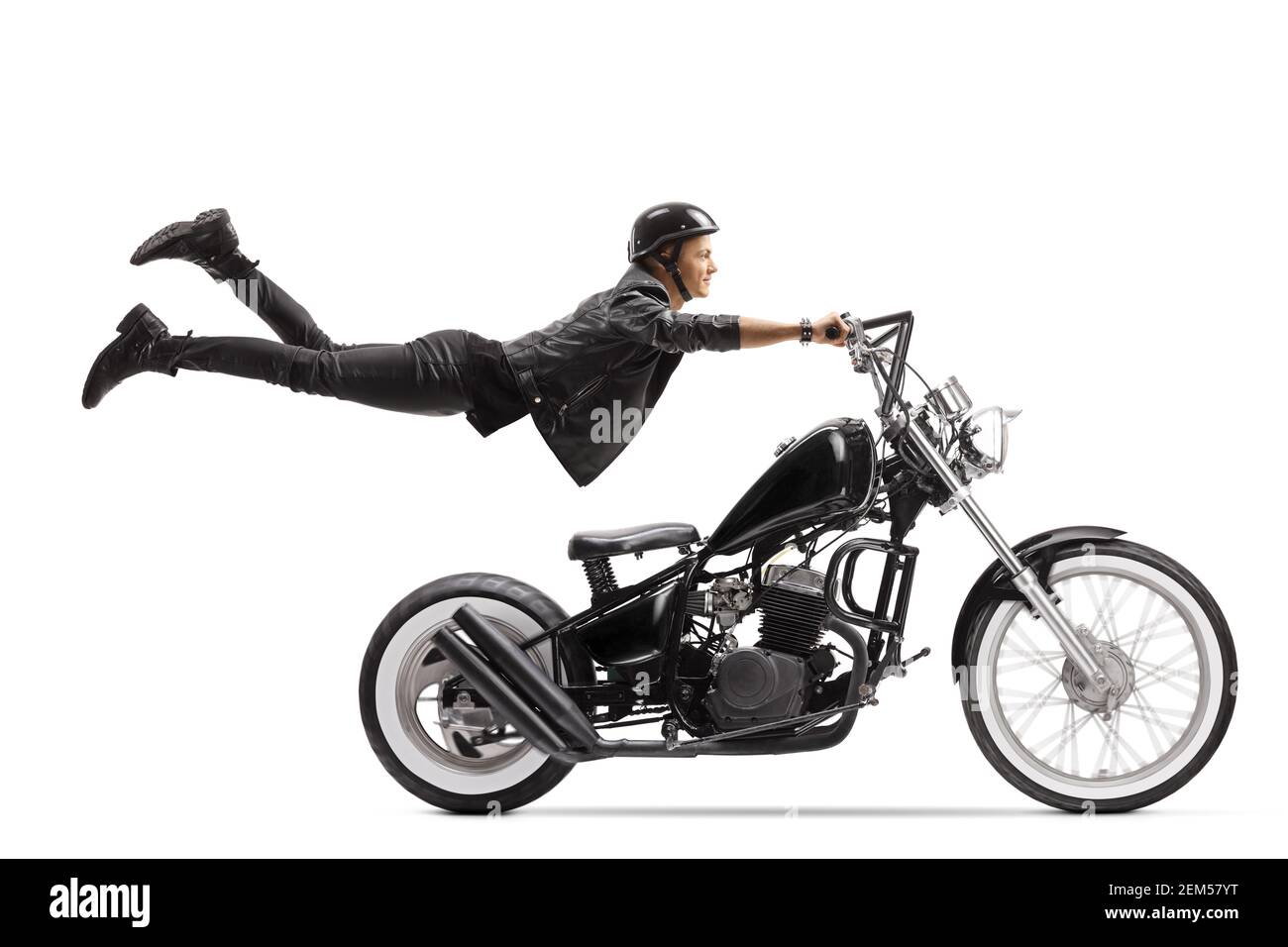 Young male biker riding a chopper and flying isolated on white ...