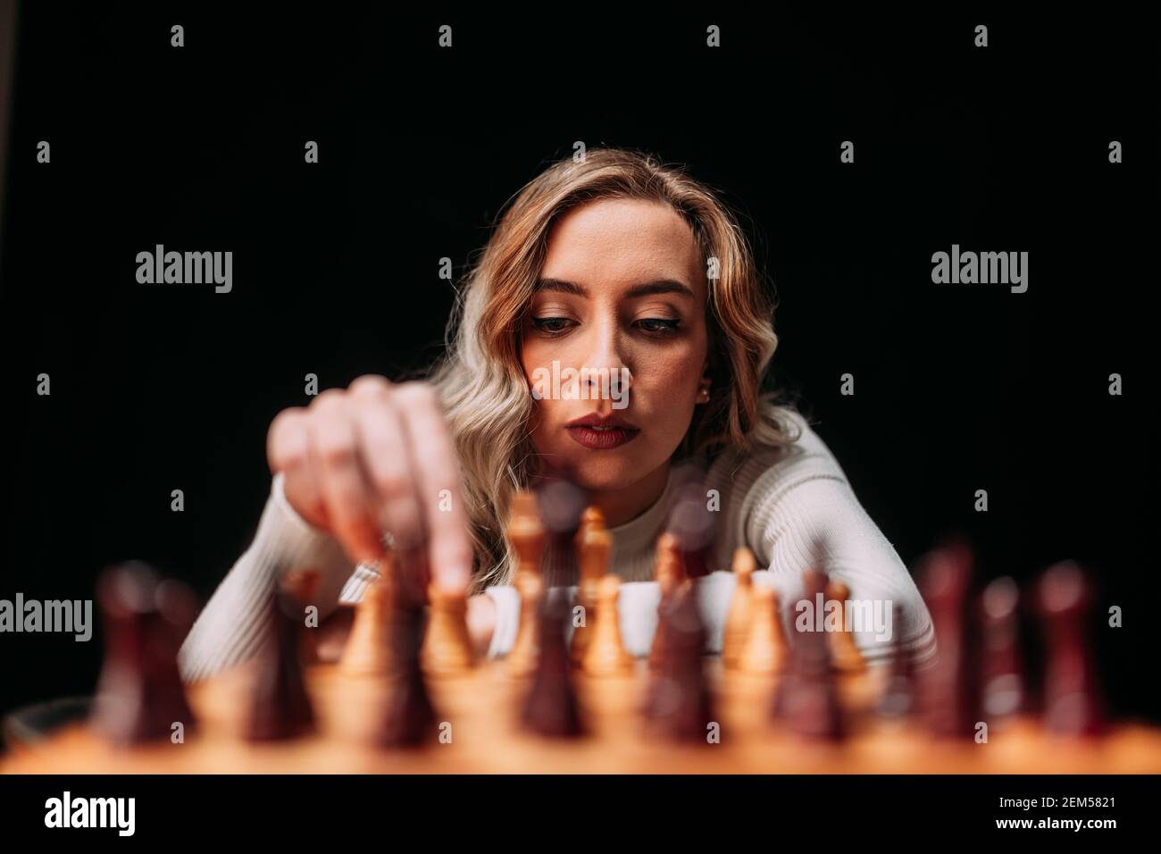 Competitive Girl Plays Chess Isolated In Black Background Stock Photo ...