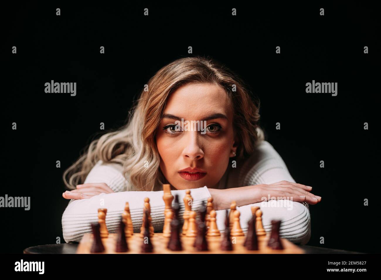 Competitive Girl Plays Chess Isolated In Black Background Stock Photo ...