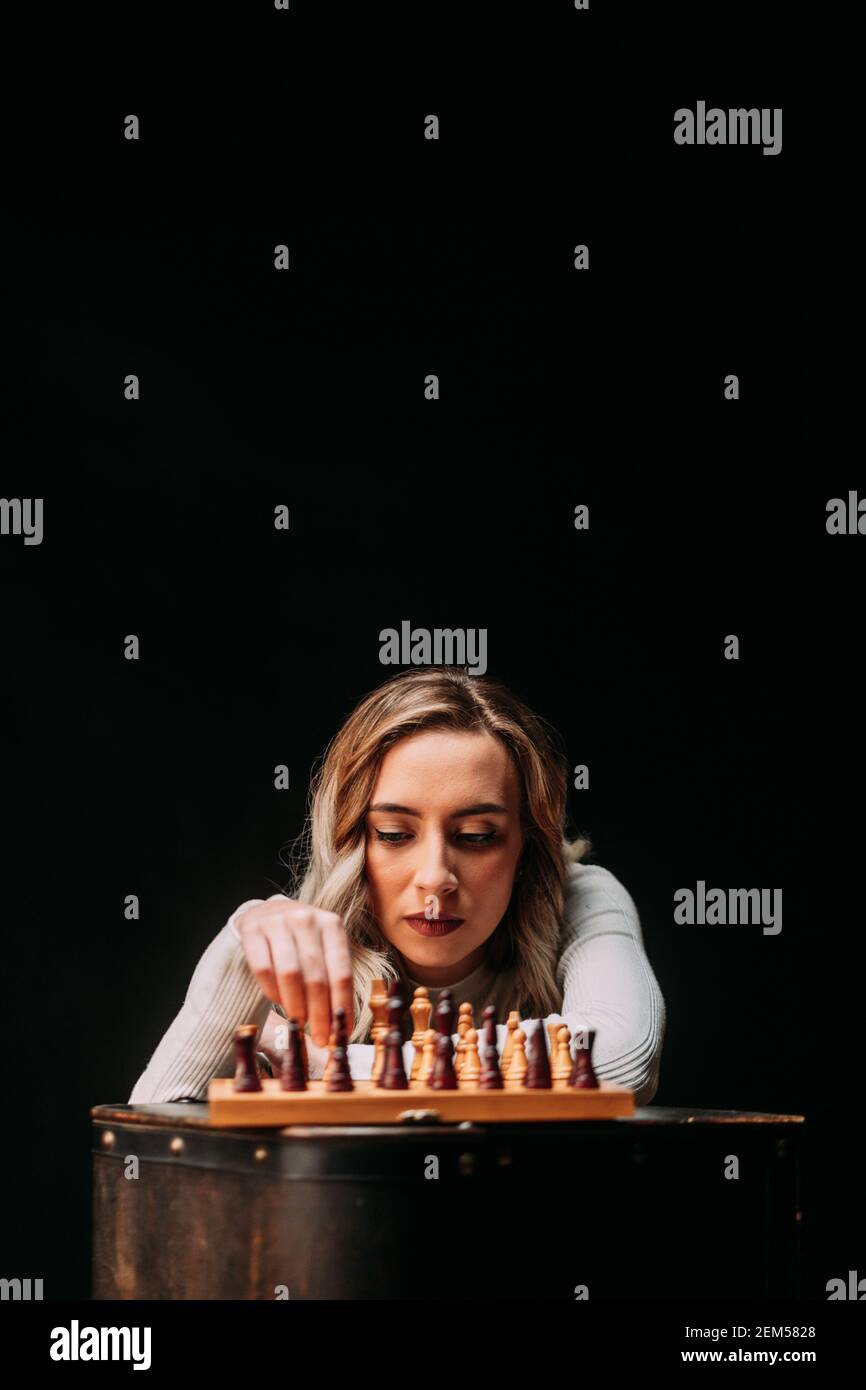 Competitive Girl Plays Chess Isolated In Black Background Stock Photo ...