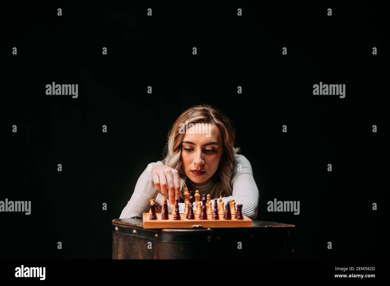 Competitive Girl Plays Chess Isolated In Black Background Stock Photo ...