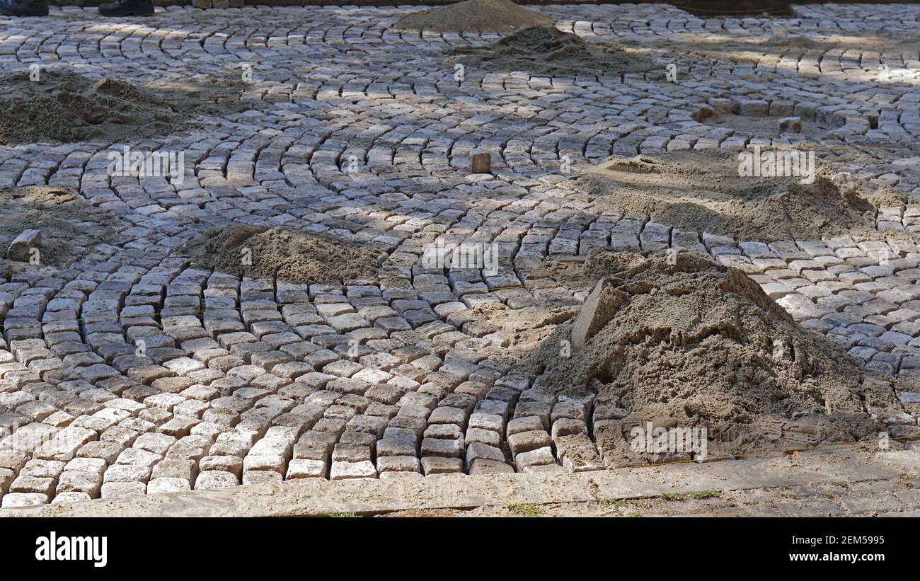 Laying cobblestone street pavement traditional way Stock Photo - Alamy