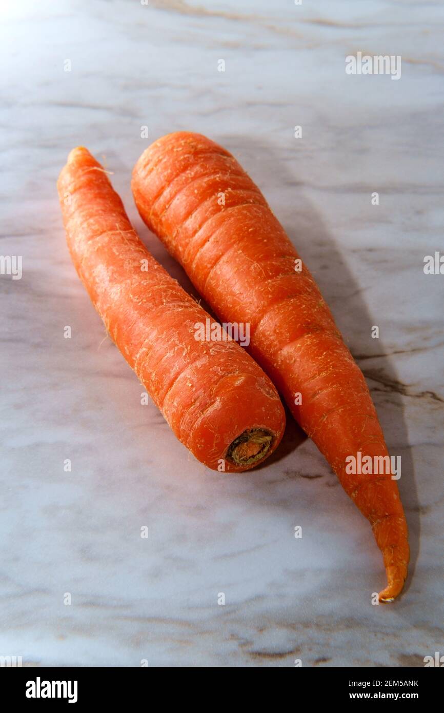 Healthy eating two carrots on marble kitchen table Stock Photo - Alamy