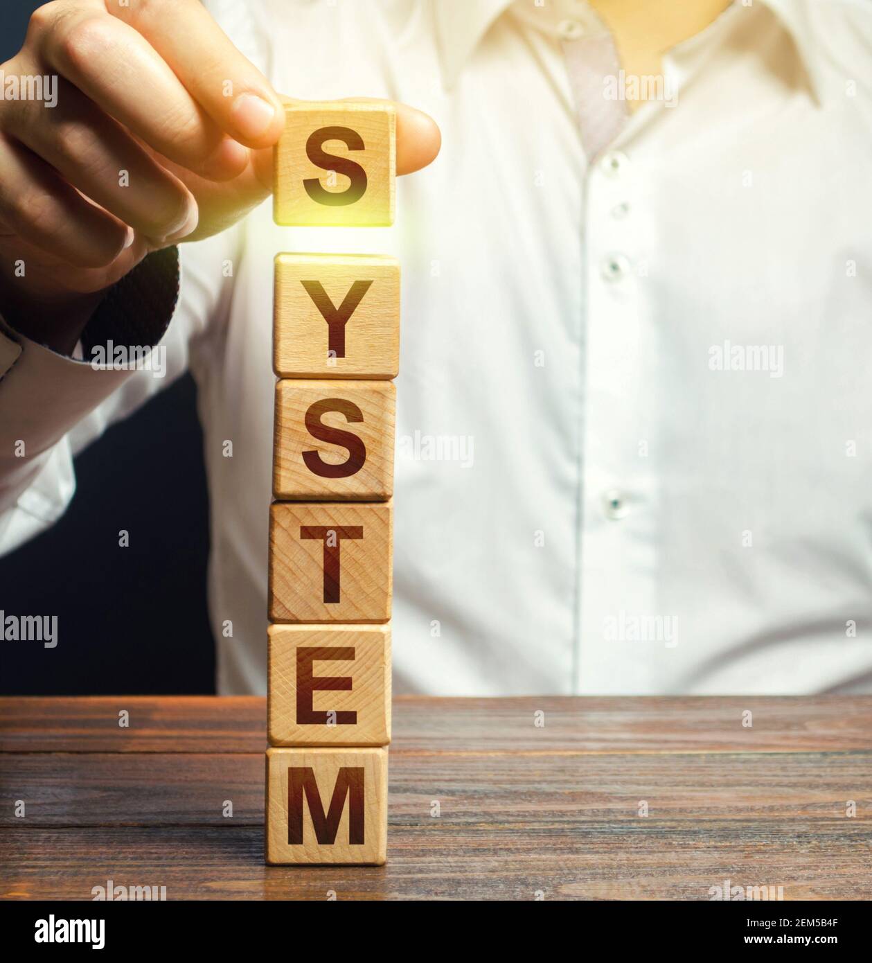 The man builds a tower of blocks the word System. Creation of a system ...