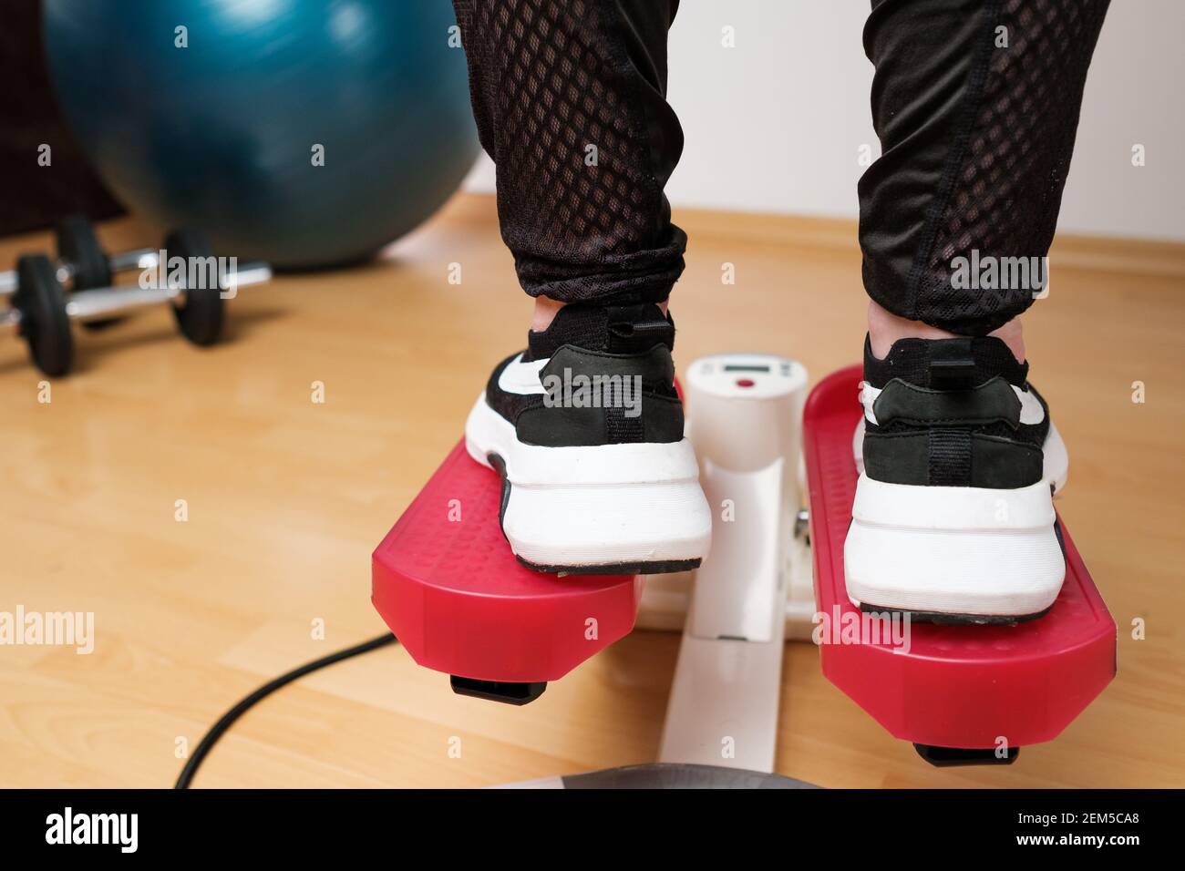 Back view on the woman feet in sneakers doing exercising on the twist ...