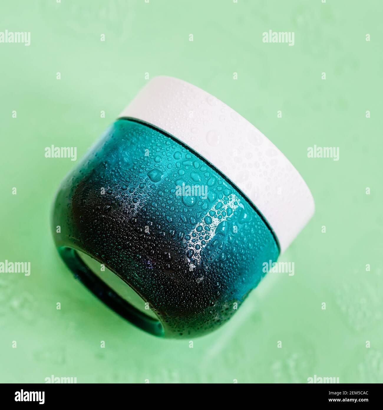 Natural organic cream in blue glass jar, water bubbles, light ...