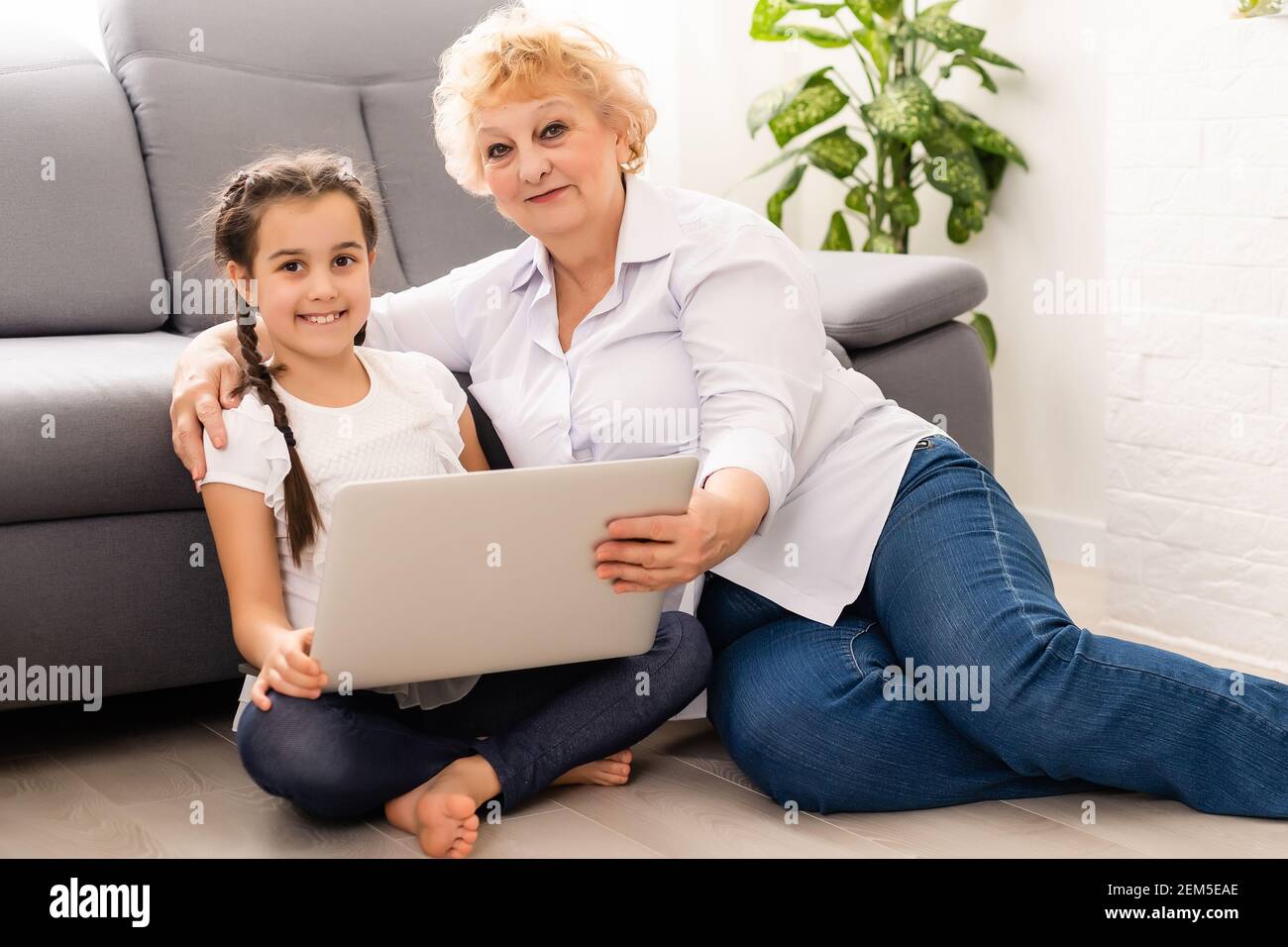 modern grandmother teaching grandchild how to use laptop computer at ...