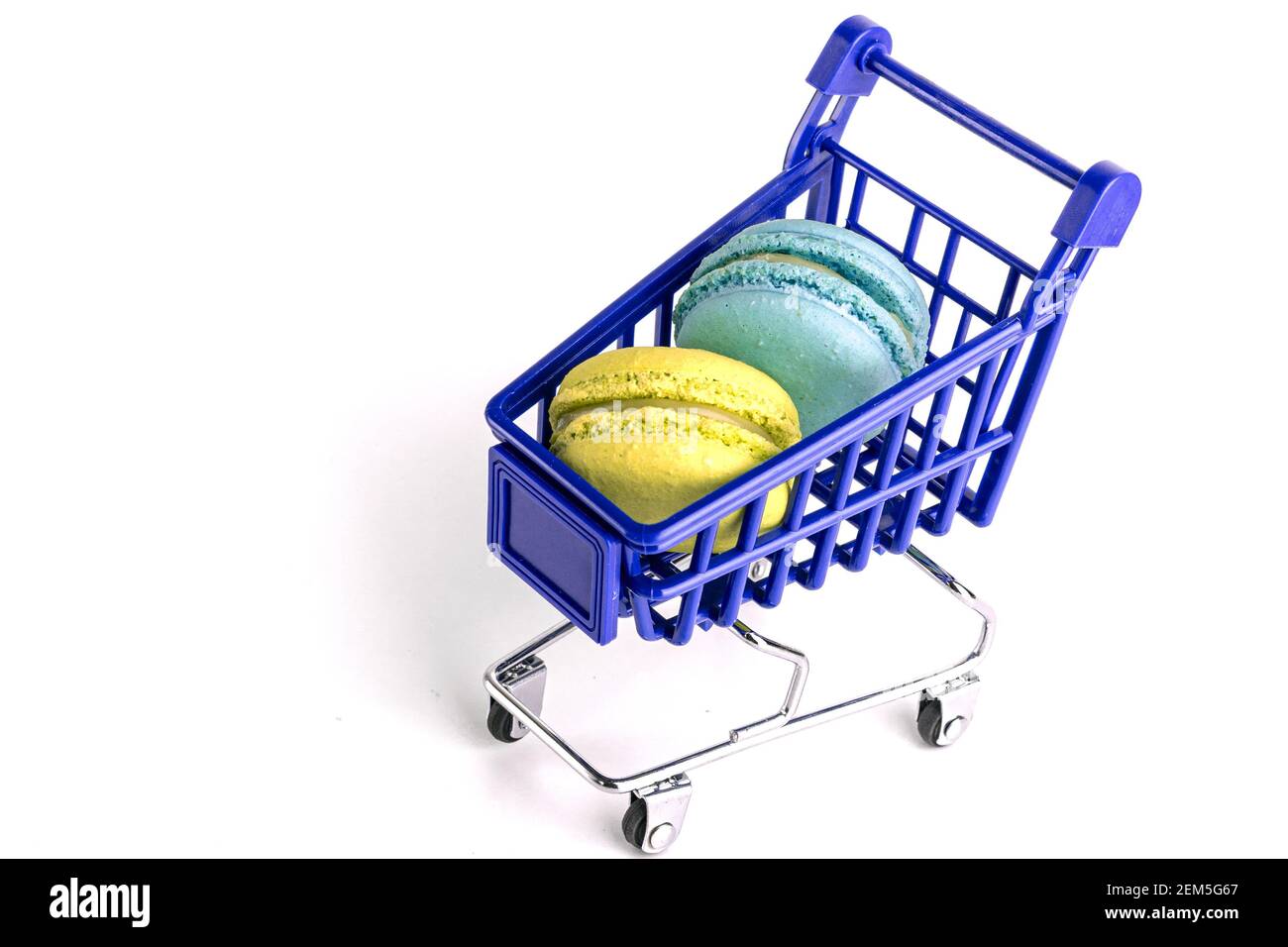 Blue and yellow macarons and metal shopping cart isolated on white ...