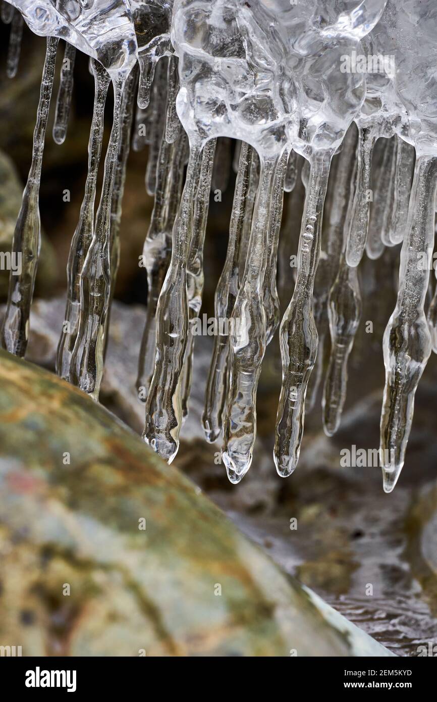 Icicles on a river flowing through a gorge in the winter Stock Photo ...