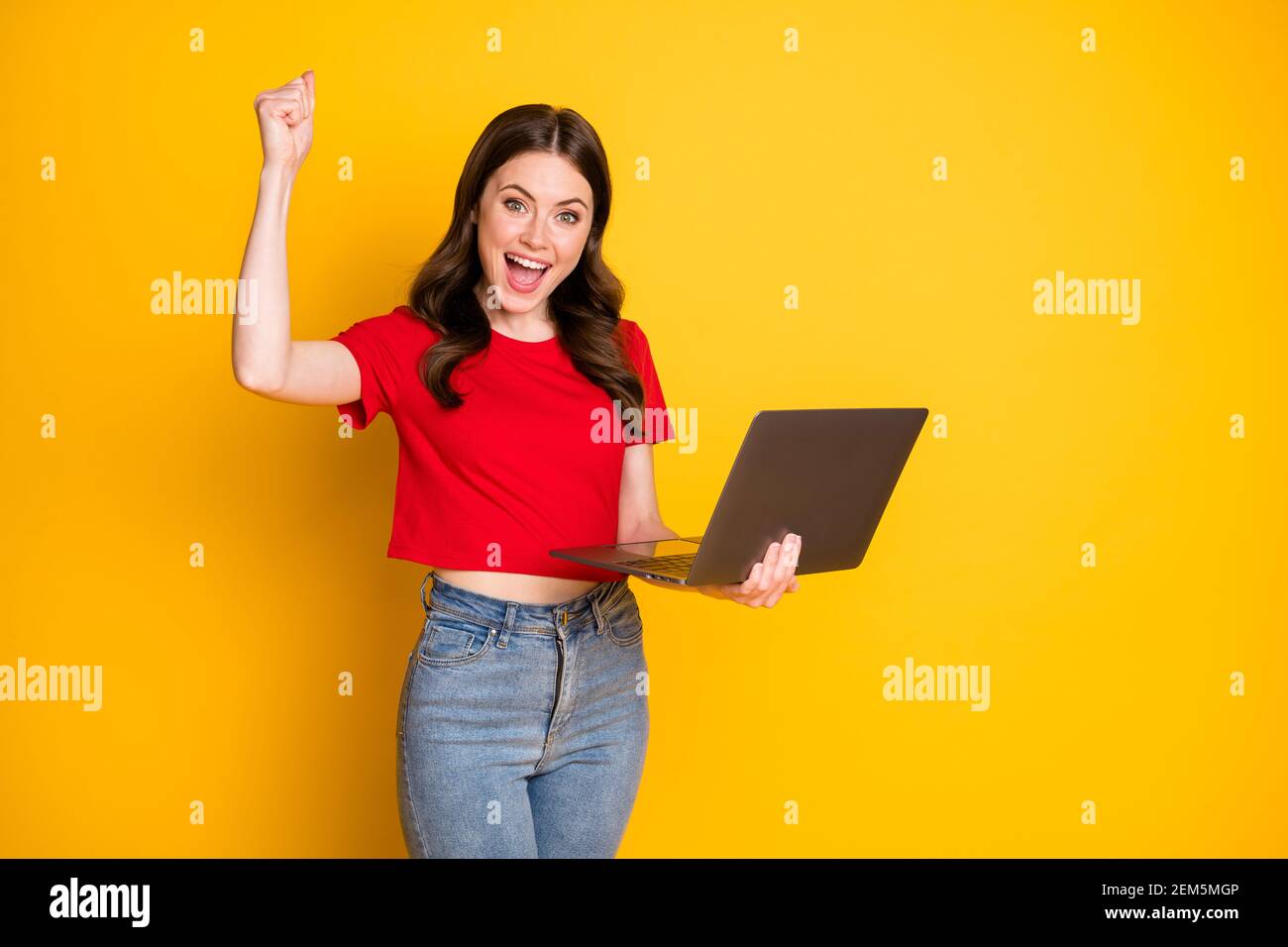 Photo of delighted girl work laptop win raise fists scream wear red t ...