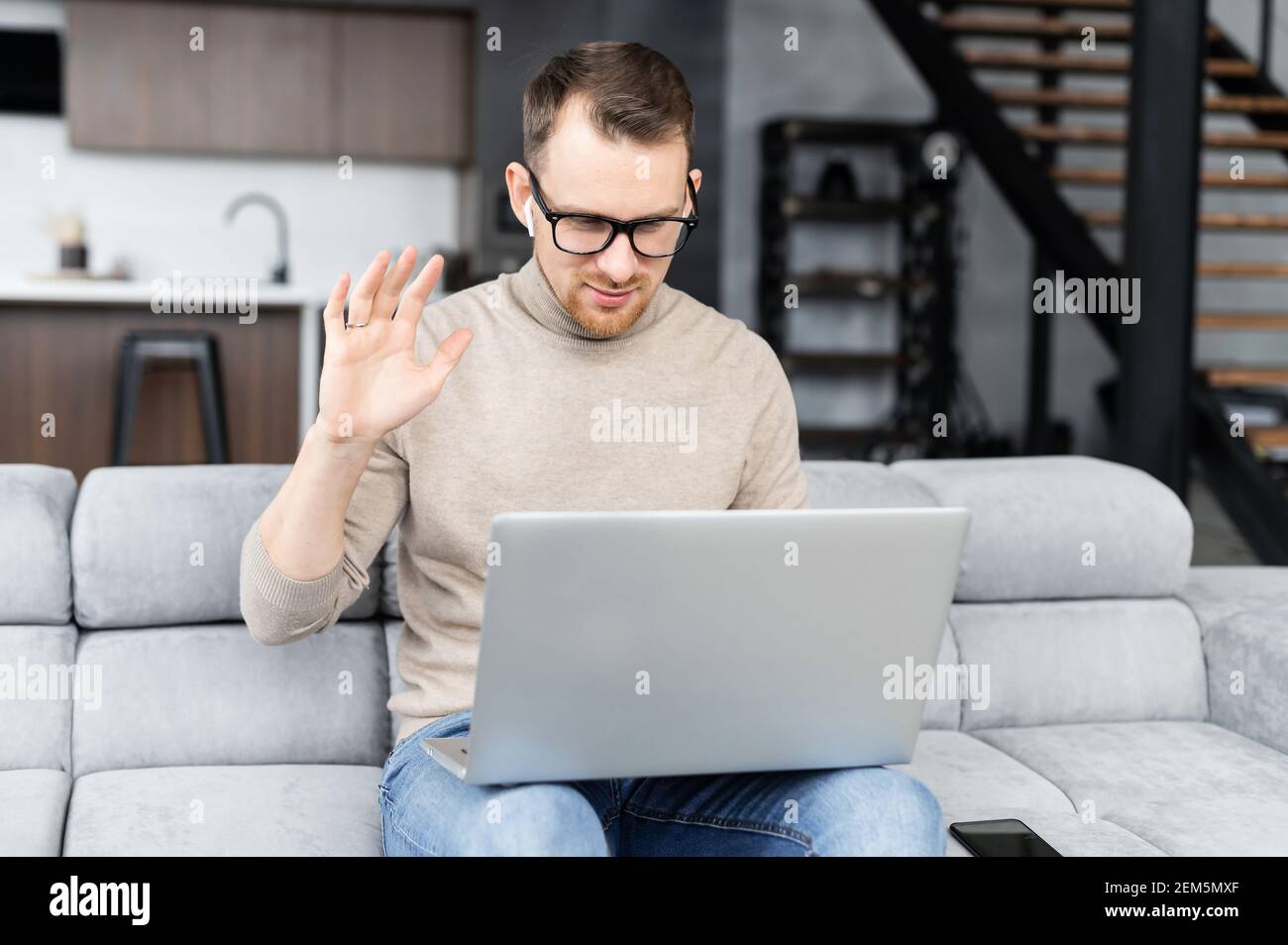 Young good-looking man is using a laptop for video connection, making ...