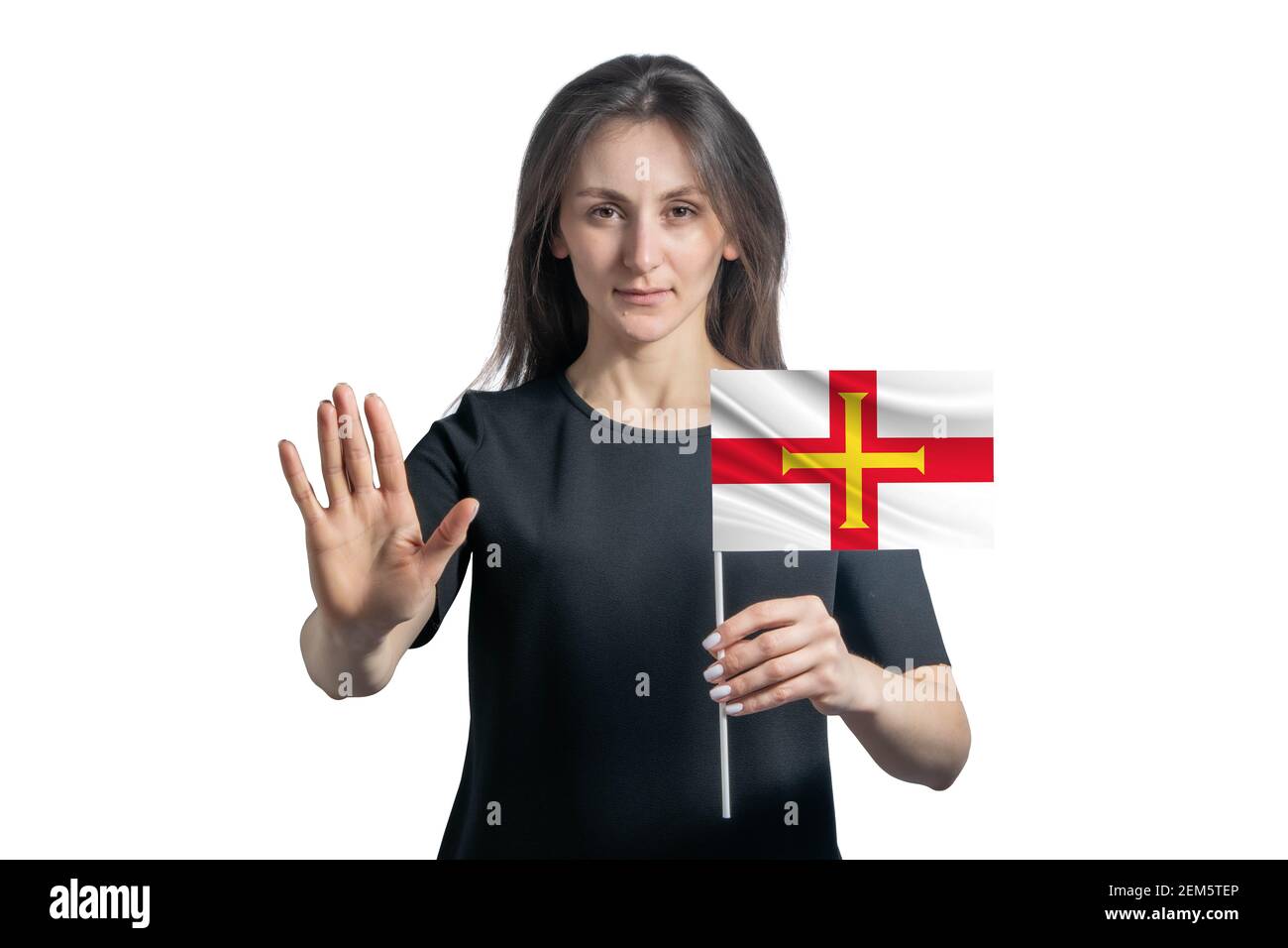 Happy young white woman holding flag of Guernsey and with a serious ...