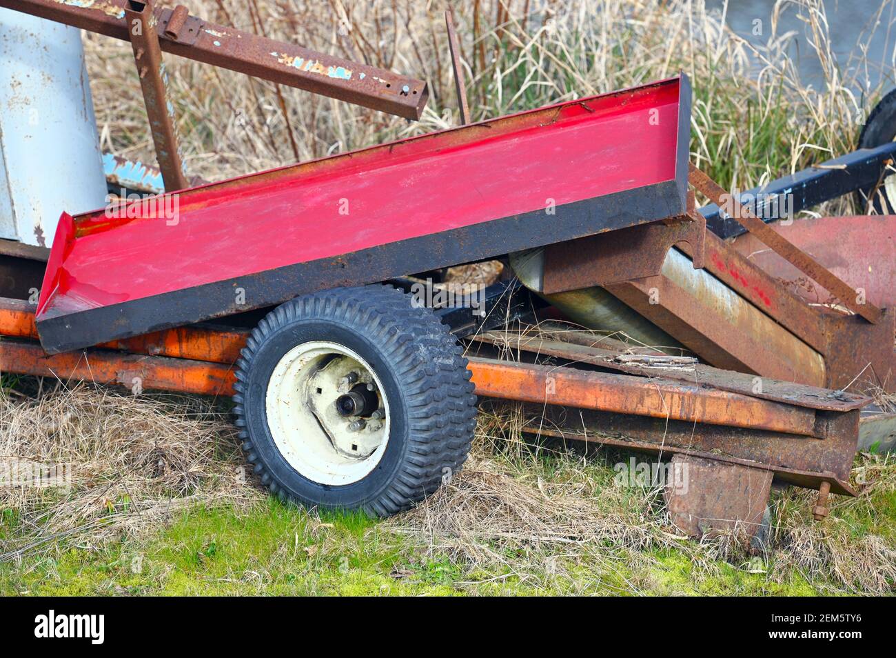 A pile of rusted scrap metal and wheel from a utility trailer Stock ...