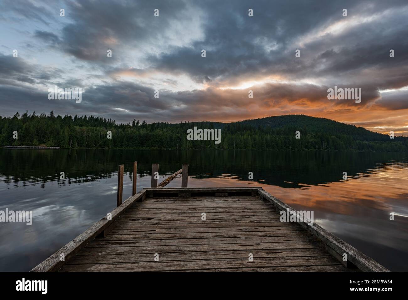 Sun setting over a wooden dock in Inland lake provincial park, British ...